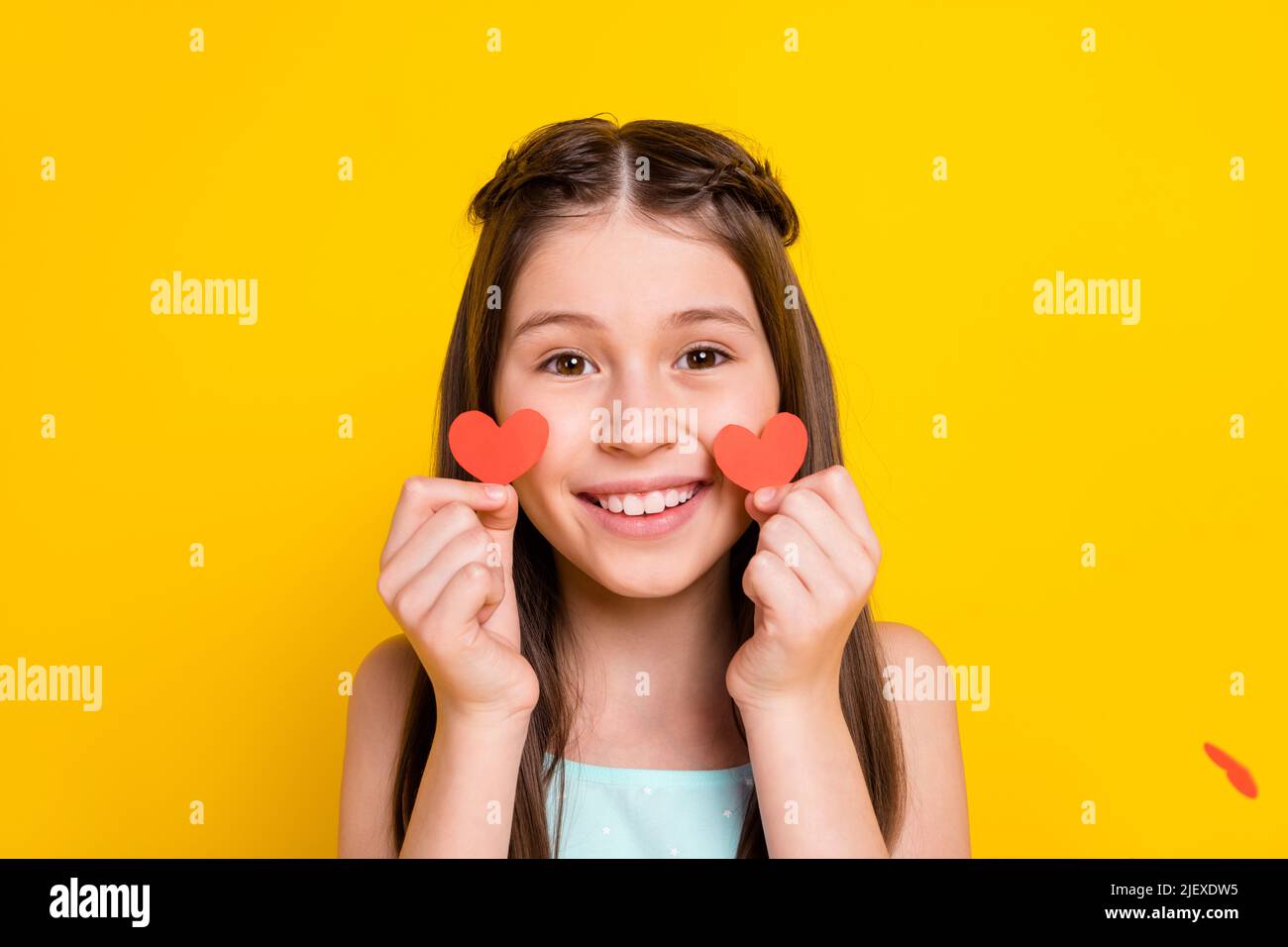 Photo of happy pretty cute little girl hold hands small red paper heart ...