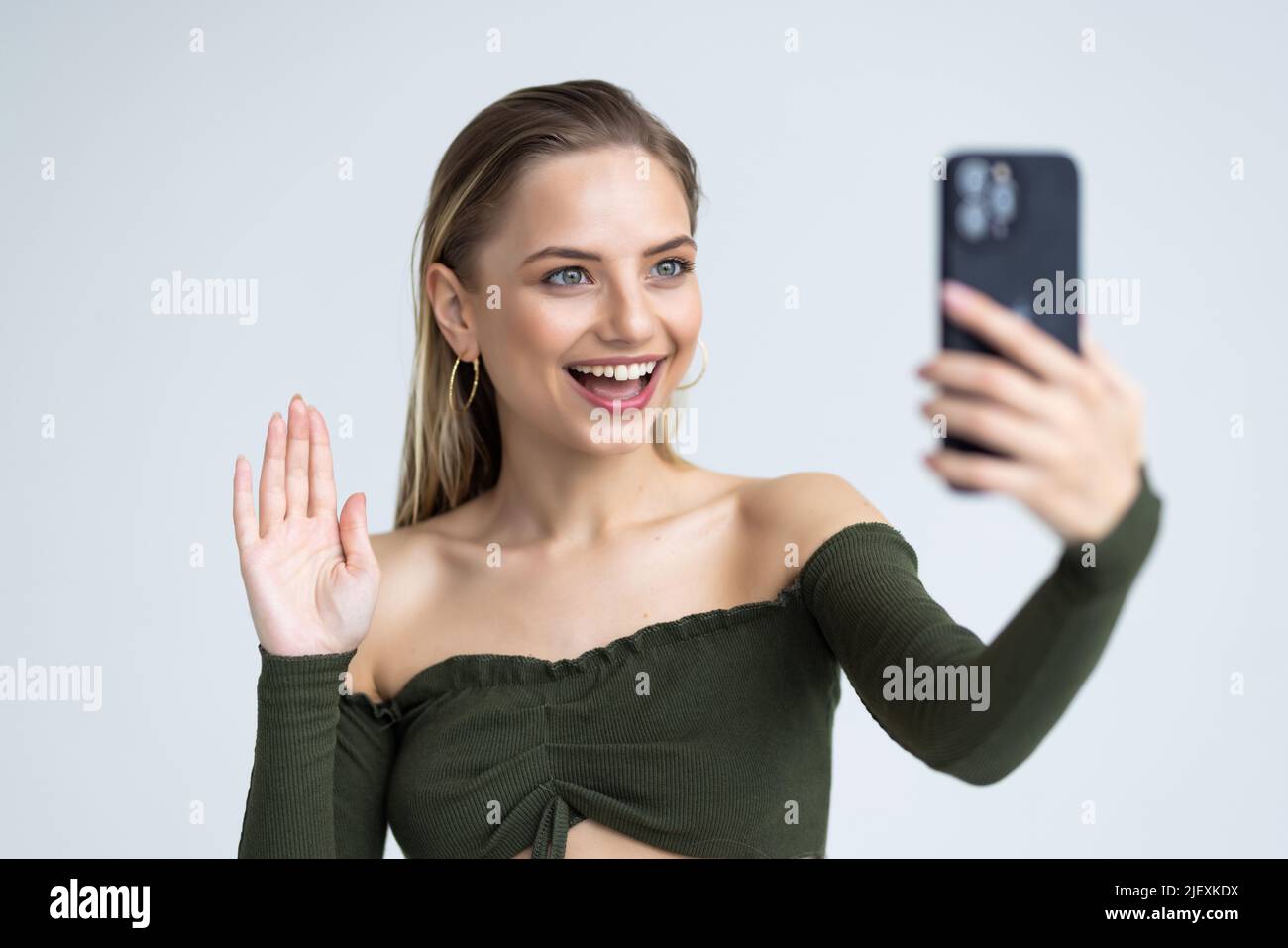 Happy young woman blogger influencer holding modern smart phone wave ...