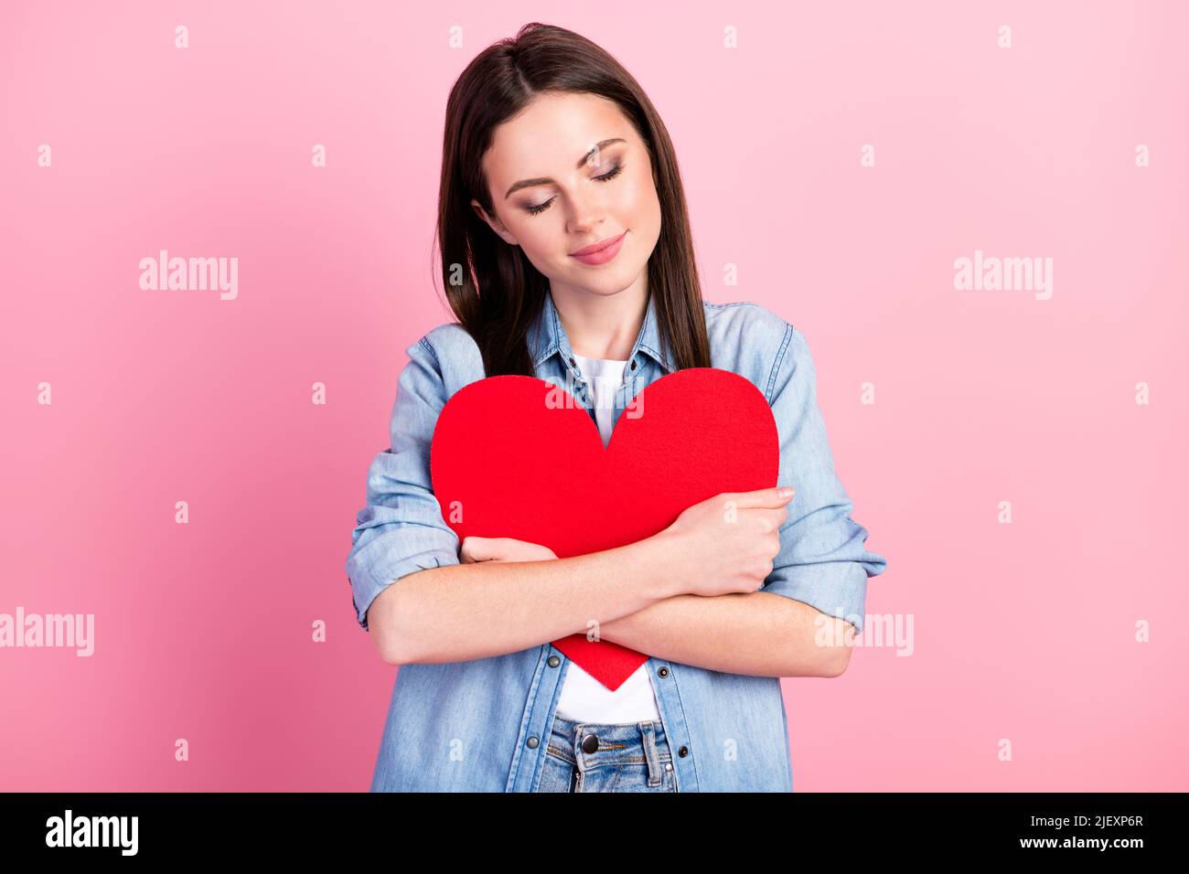 Photo of attractive calm young woman hug big red heard figure isolated ...