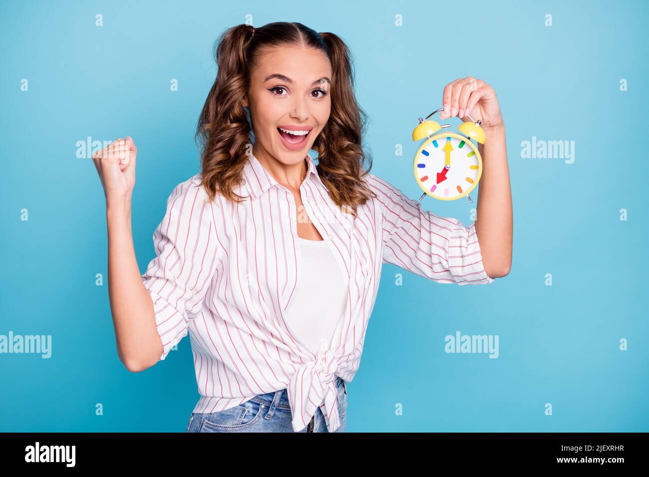Photo portrait girl holding watch overjoyed gesturing like winner ...