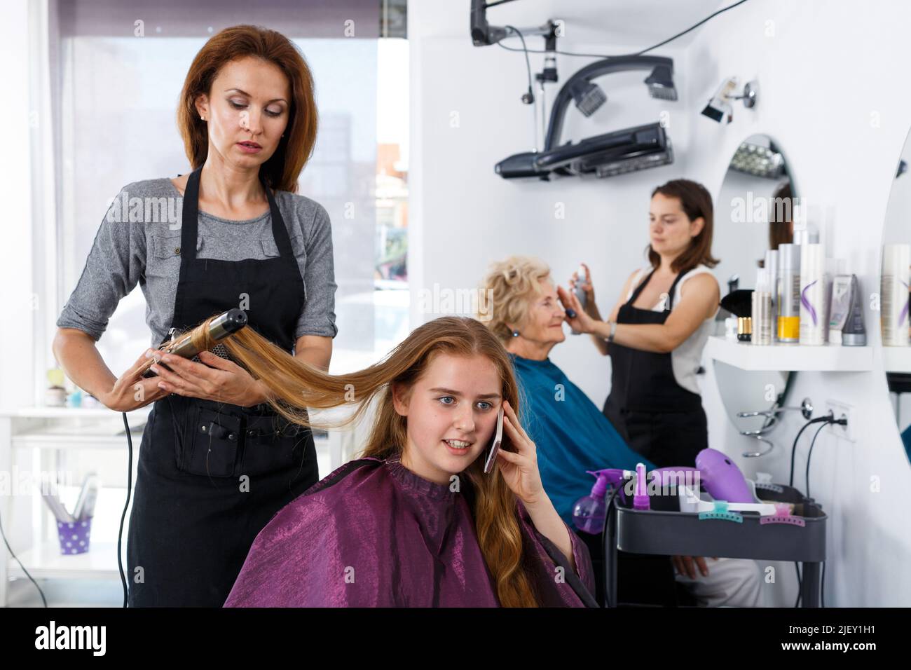 Girl talking on phone in hair salon Stock Photo - Alamy
