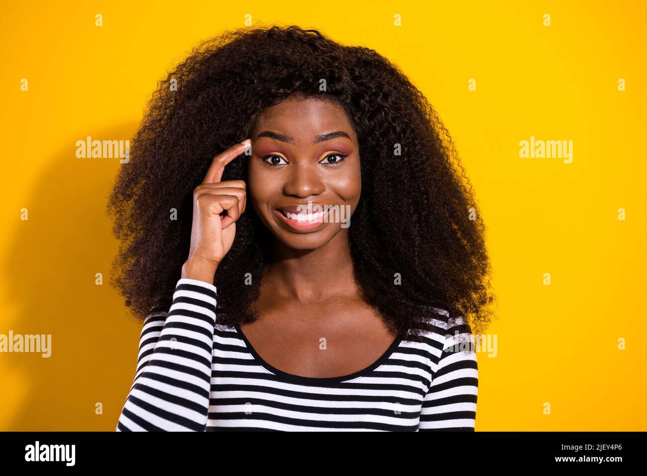 Photo portrait of young model keeping finger near forehead smiling ...
