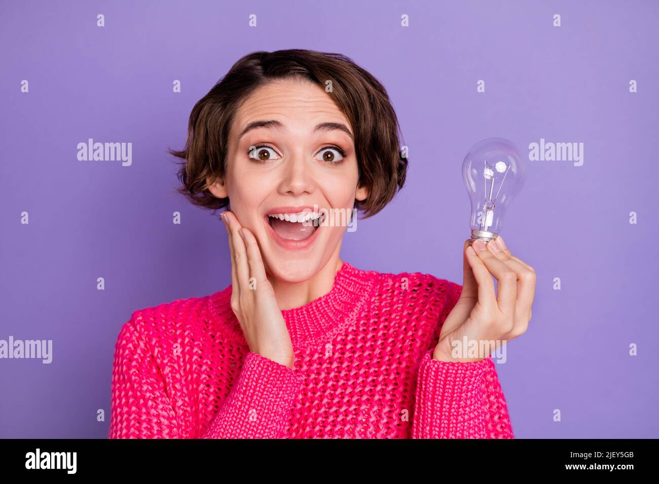 Photo of young excited girl happy smile amazed hold light bulb idea ...