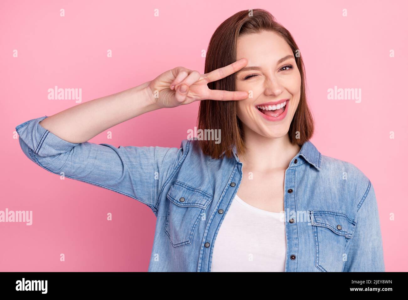 Photo portrait of girl smiling showing peace v-sign winking blinking ...