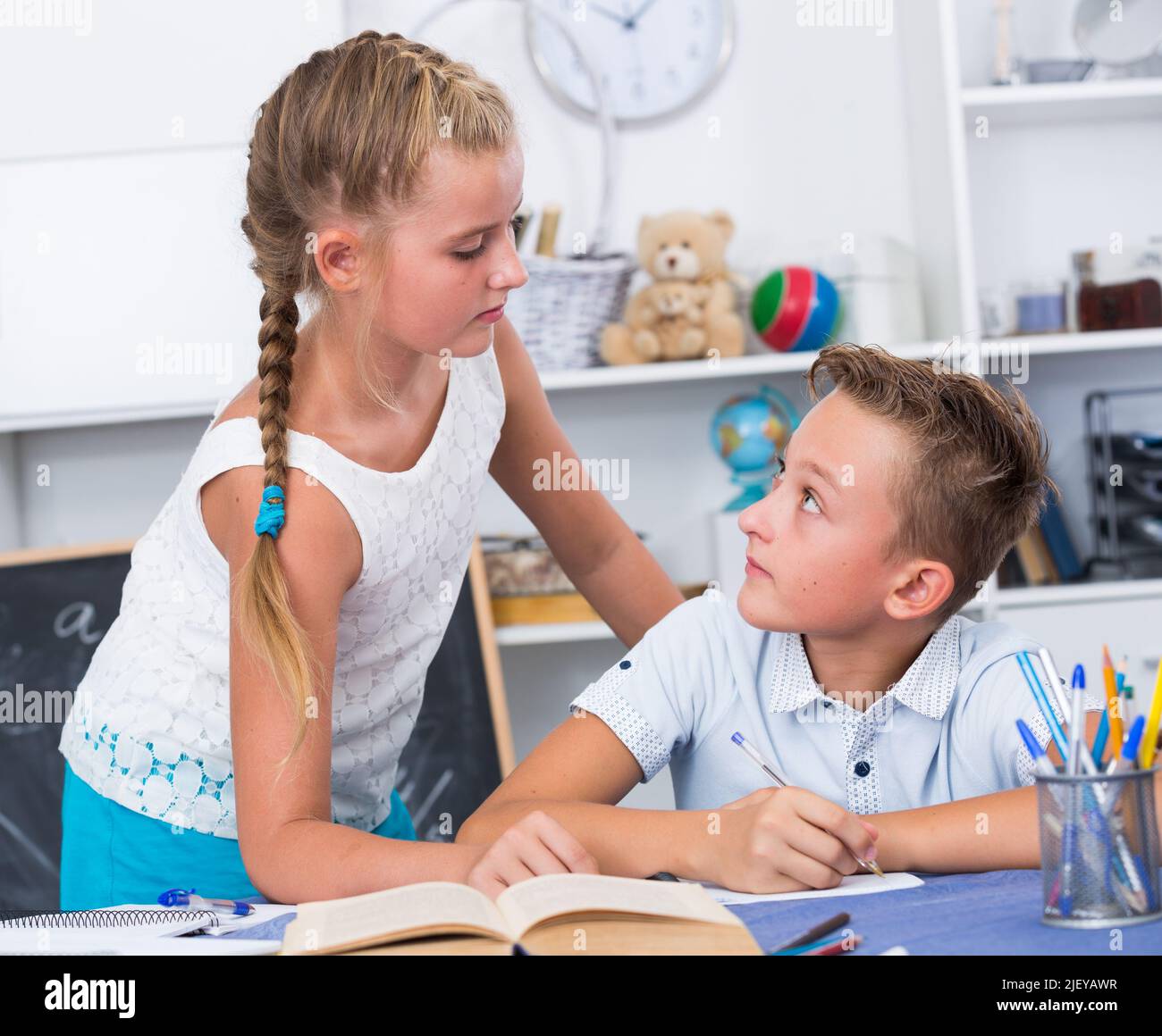 Girl is helping brother doing homework Stock Photo - Alamy