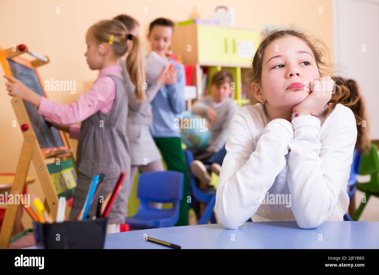 Sad girl sitting in classroom hi-res stock photography and images - Alamy