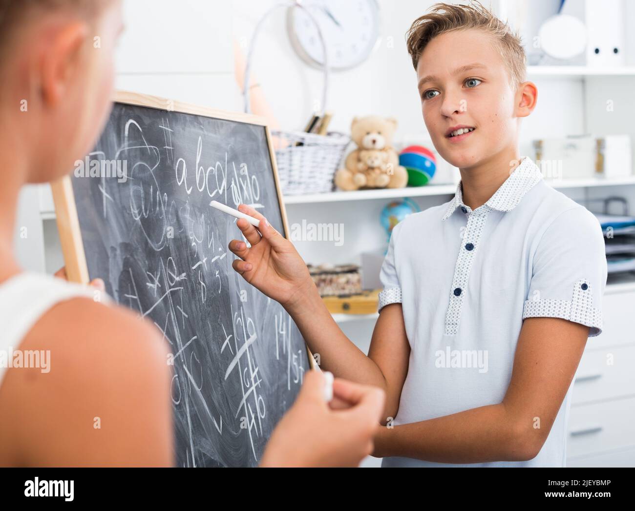 Boy with girl are writing on desk their homework on math Stock Photo ...