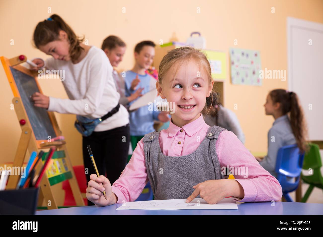 Happy little schoolgirl drawing during break Stock Photo - Alamy