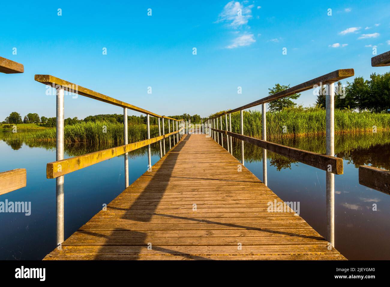 Wooden pantoon bridge going to small island of lake. Pedestrian bridge ...
