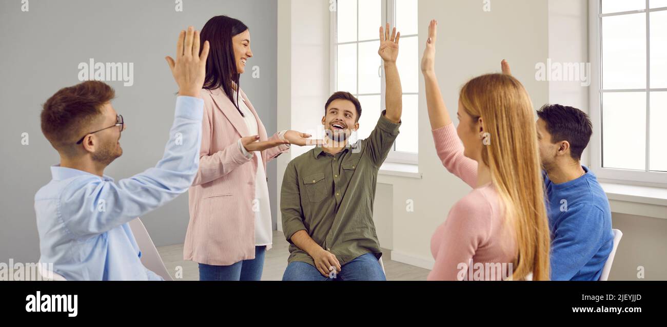 Team of happy young business people voting or making suggestions during ...