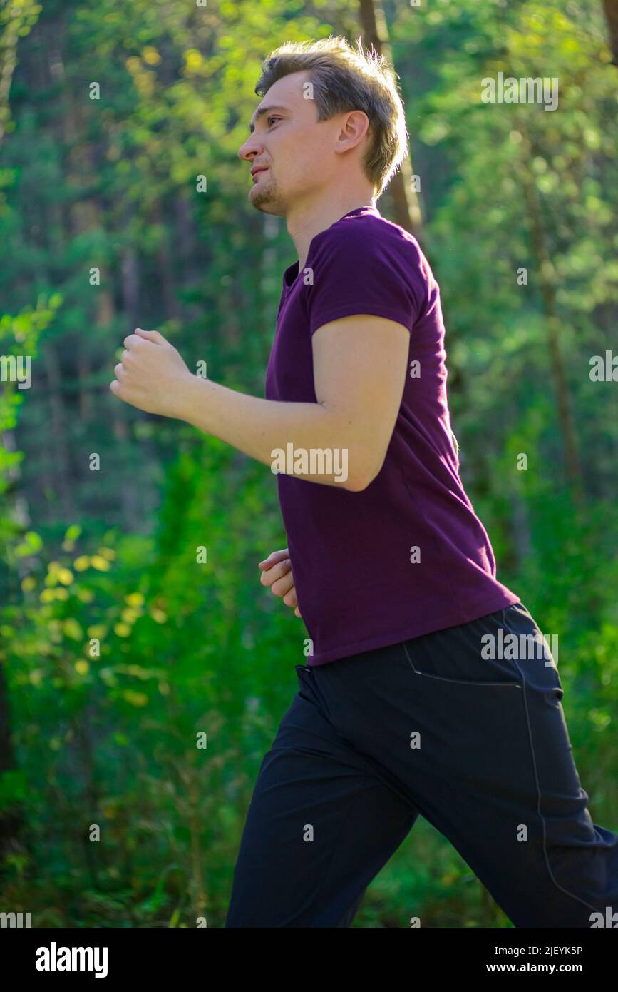 Running man jogging in city park at beautiful summer day. Sport fitness ...