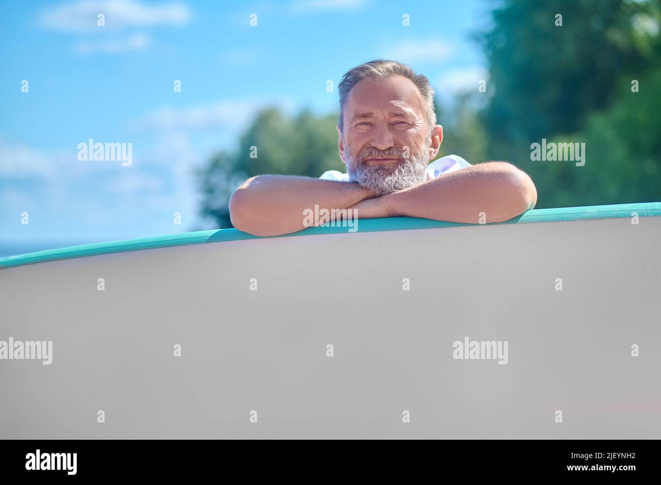 Man resting hands on rowing board looking at camera Stock Photo - Alamy