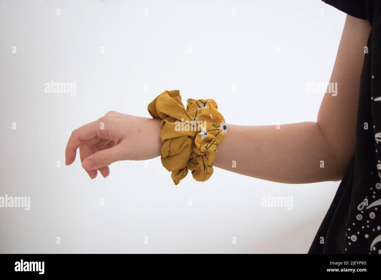 girl with two yellow hair scrunchies on her wrist Stock Photo - Alamy