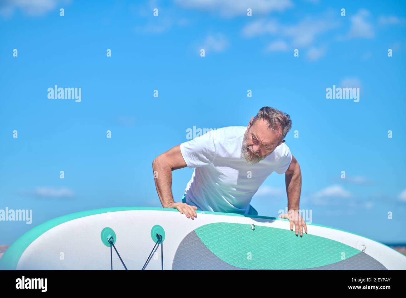 Man looking intently at rowing board Stock Photo - Alamy