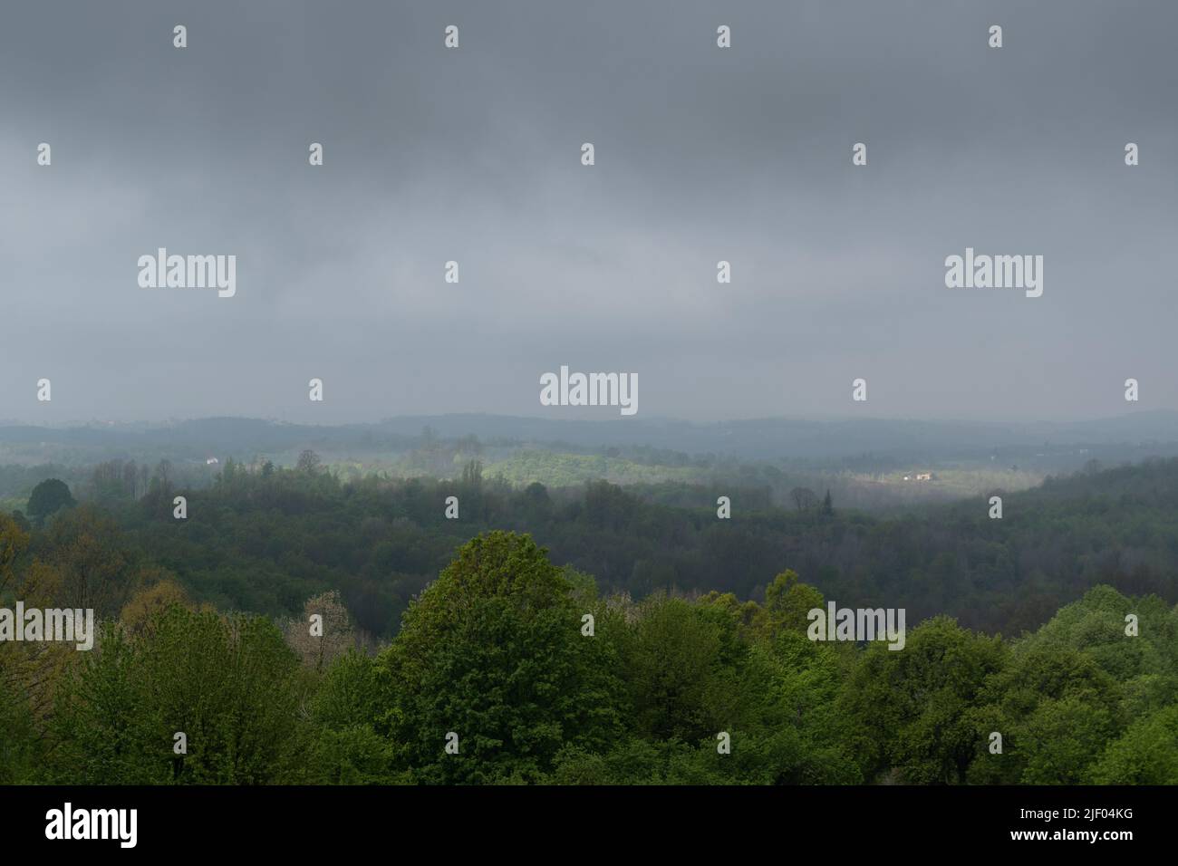 Bright sun patches on hilly countryside, hills overgrown with lush ...