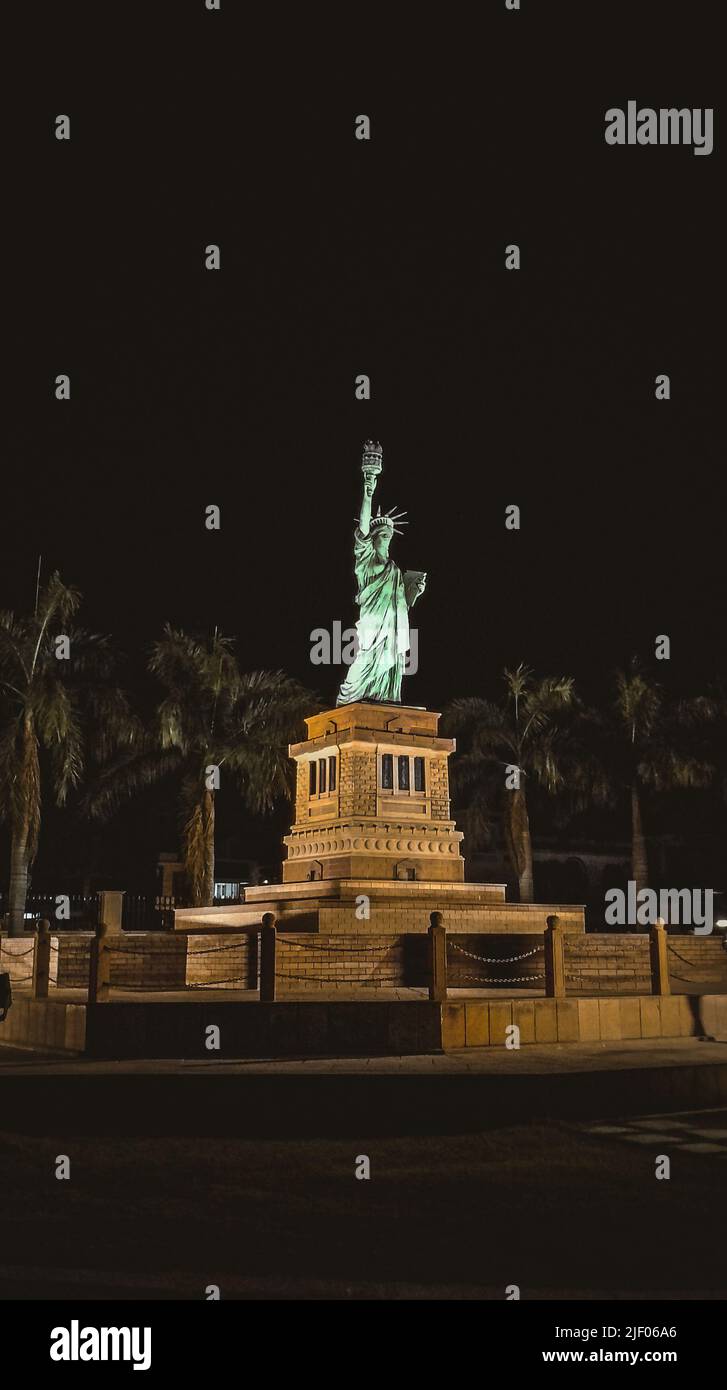 Beautiful vertical view of the Statue of Liberty illuminated by night ...