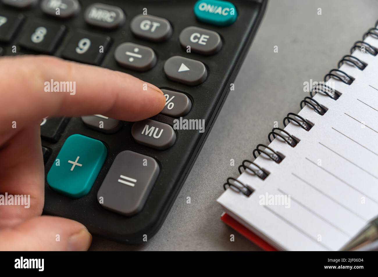 Close-up of male hand doing calculations on calculator. Index finger ...