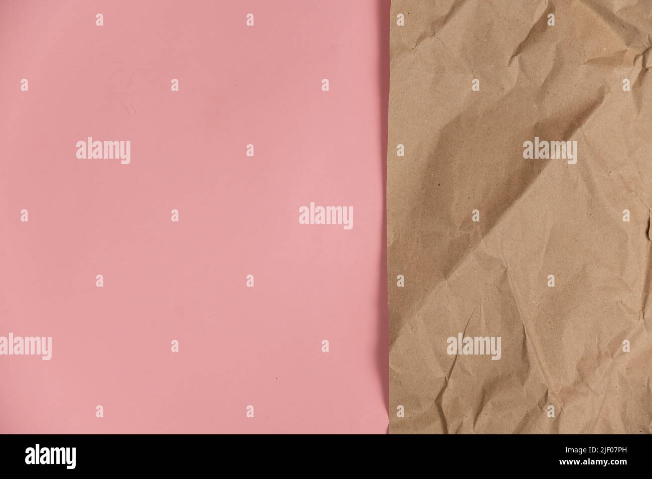 Wrapping paper against a pink background. Crumpled sheet of light brown ...