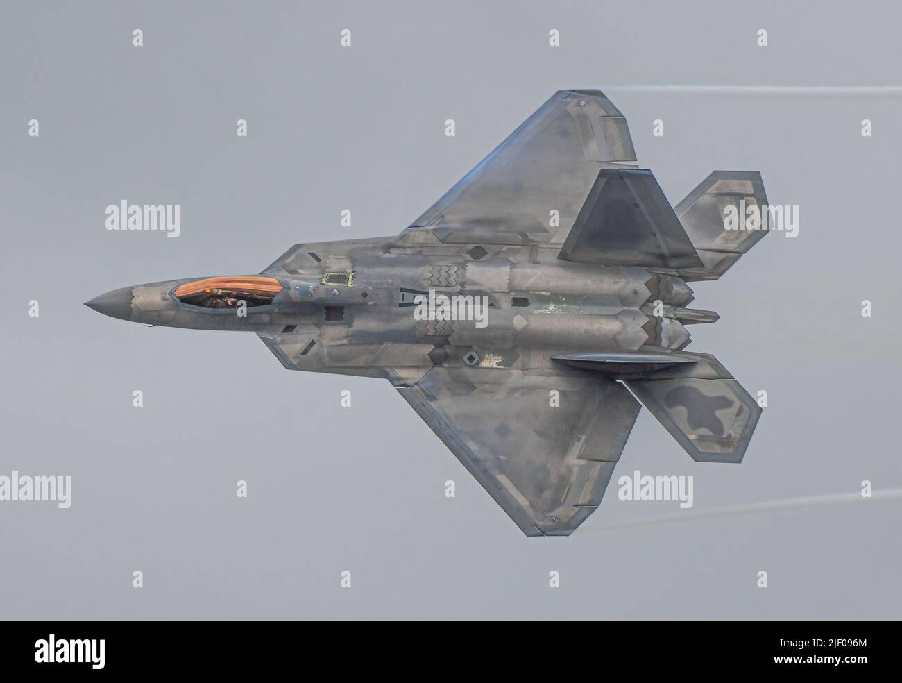 A low angle shot of a F-22 Raptor jet flying in the sky Stock Photo - Alamy