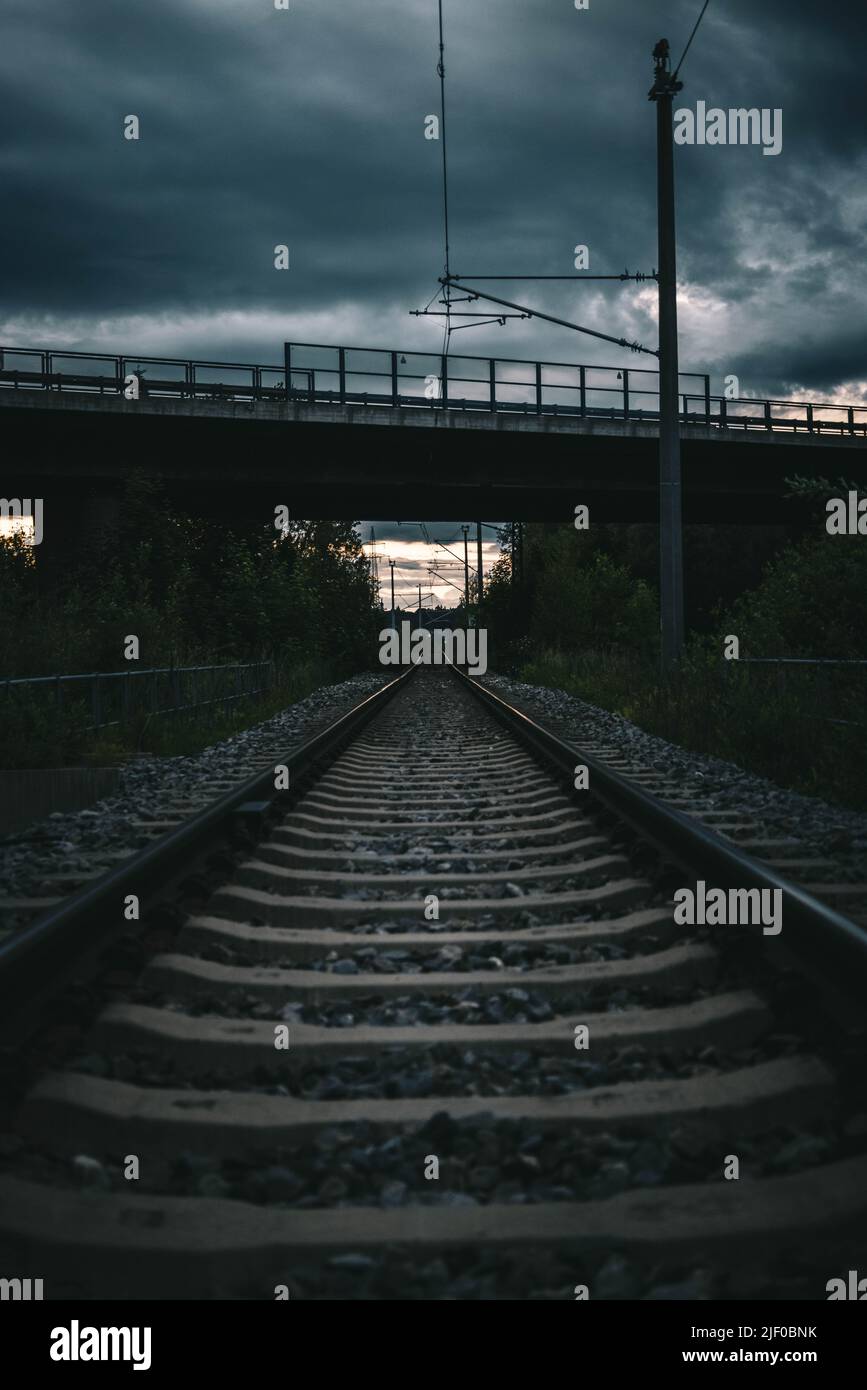 A vertical of empty railroad tracks that pass under a viaduct on a ...
