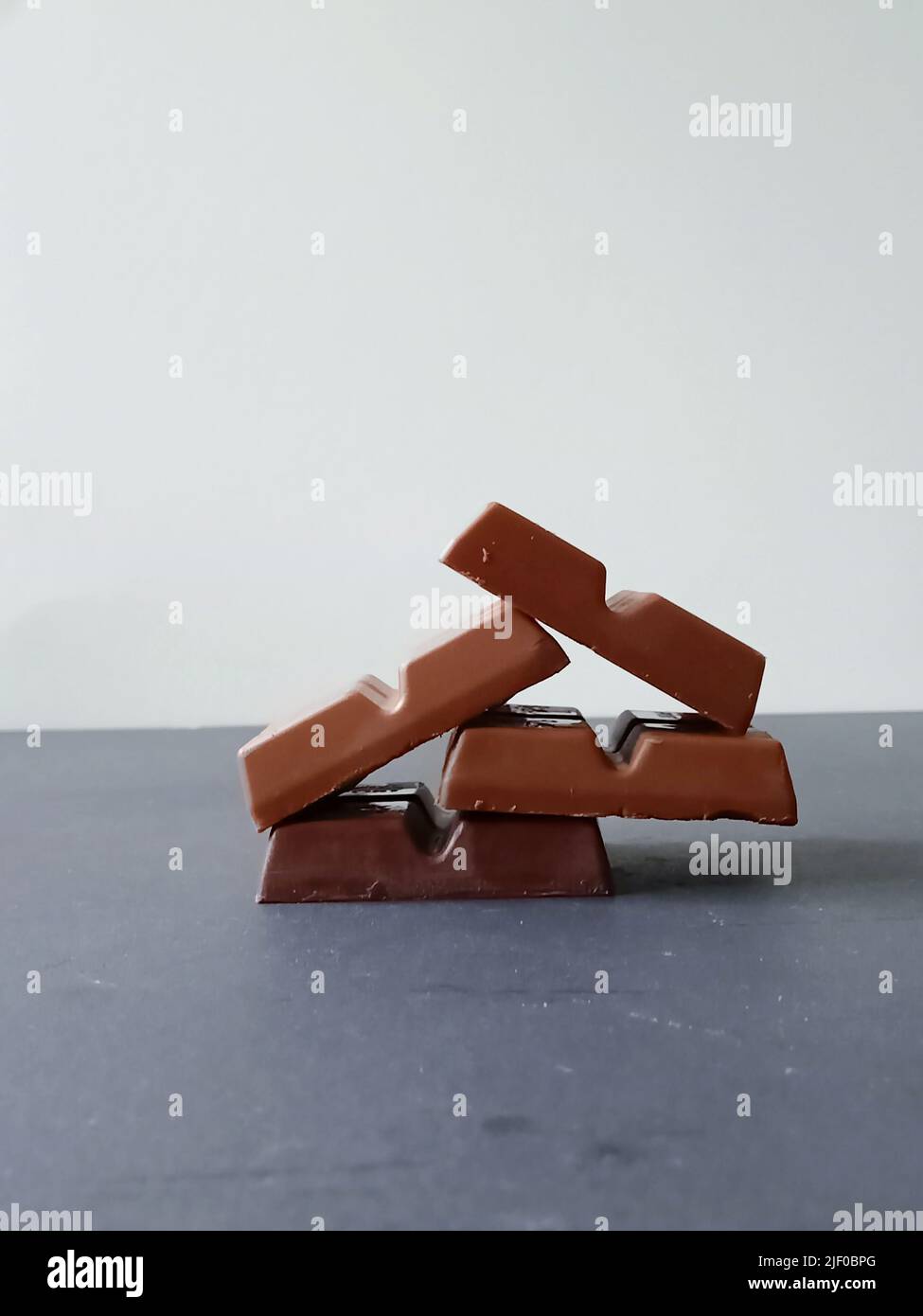 A vertical shot of a stack of milk chocolate bars on the table Stock ...