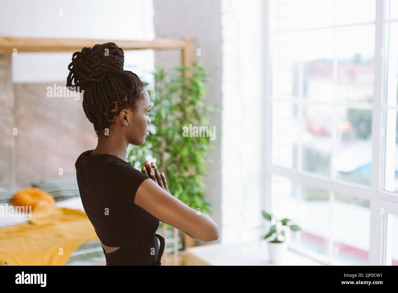 Rearview mindful, meditating young multicultural woman in black ...