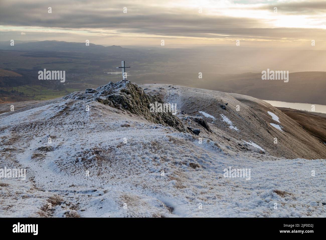 Heaven rays behind a Iron Cross memorial near the summit of Ben Ledi ...