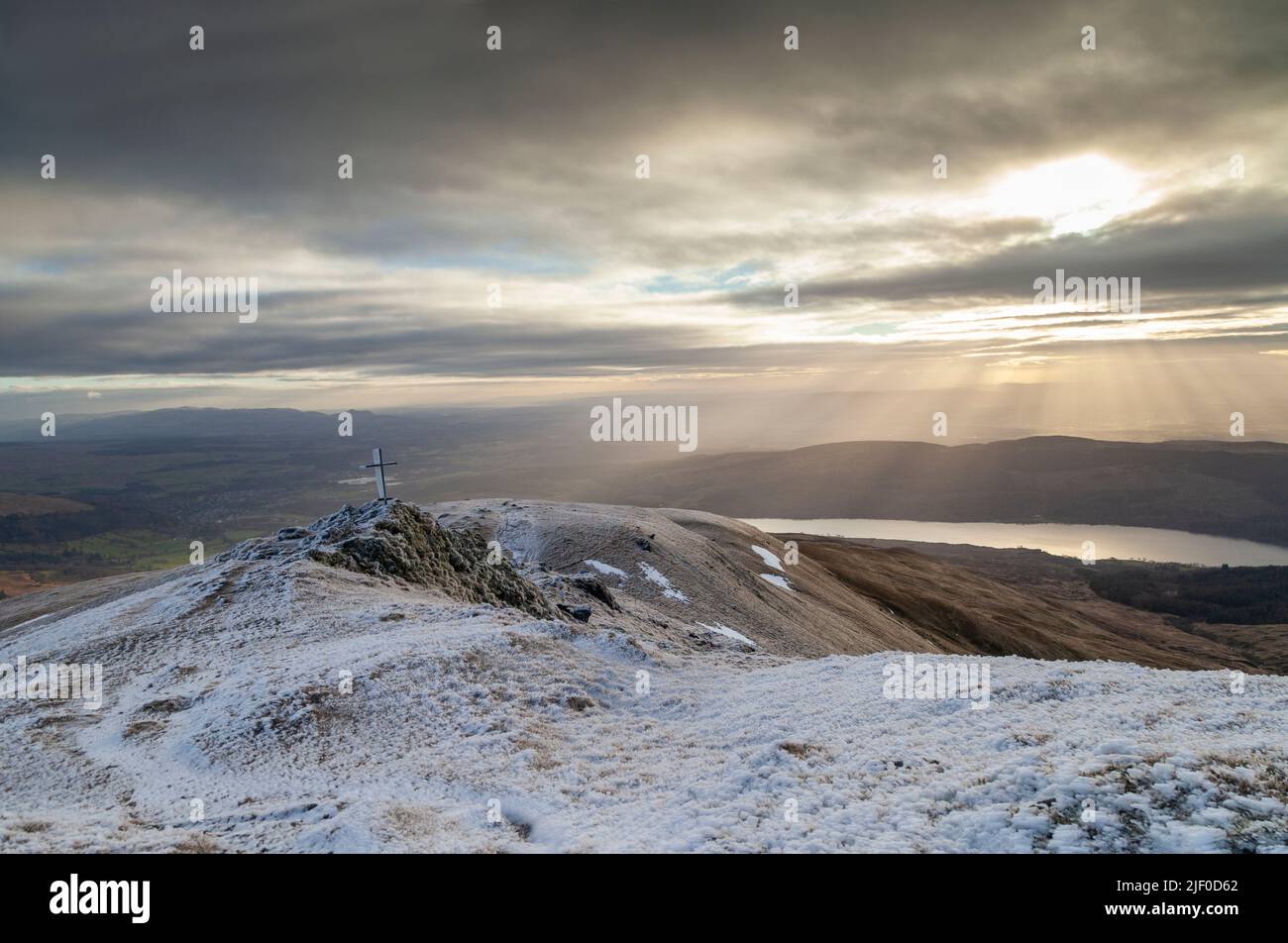 Heaven rays behind a Iron Cross memorial near the summit of Ben Ledi ...