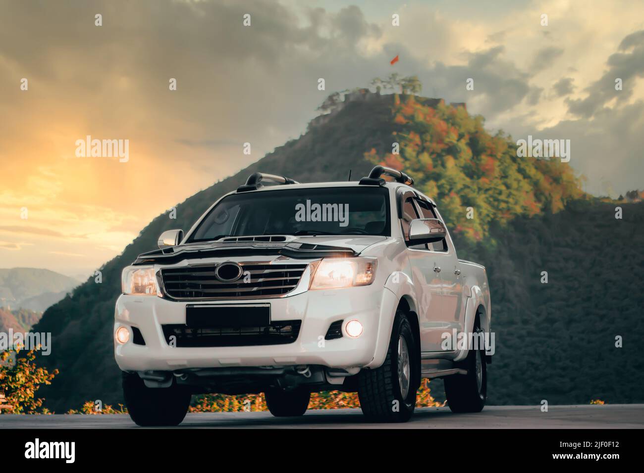 Modern 4x4 Pick-up truck on nature against to mountain in sunset. Off ...