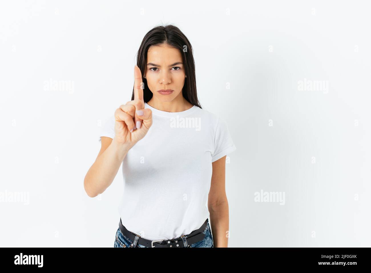 Displeased young woman showing her index finger in stopping gesture ...
