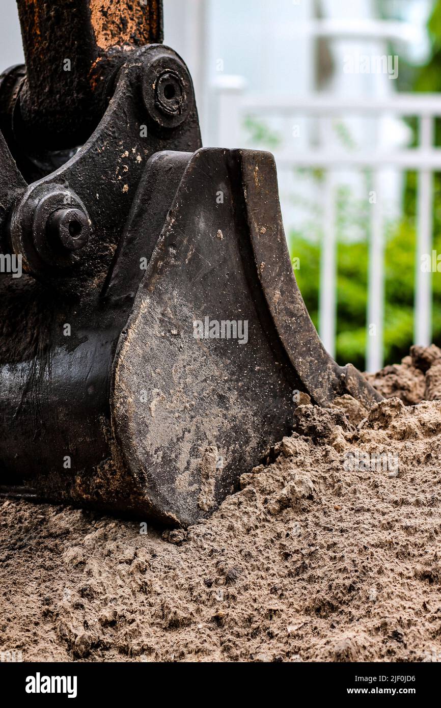 A vertical shot of excavator bucket in the ground Stock Photo - Alamy