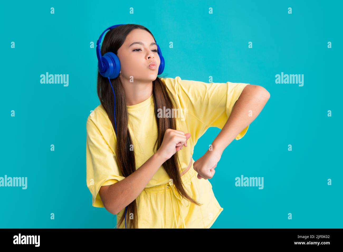 Funny face. Teenager in modern wireless headphones enjoying song music ...