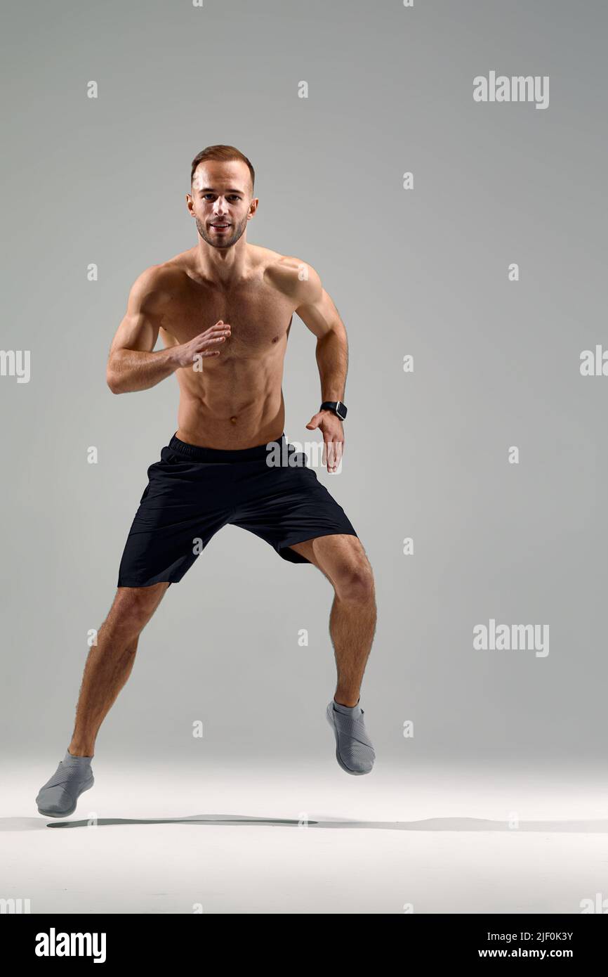 In jump. Caucasian professional sportsman training isolated on white ...