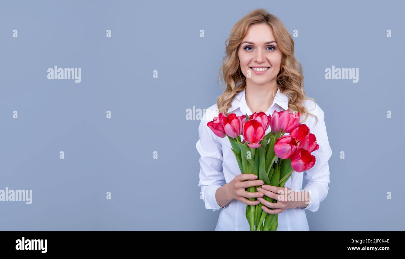 smiling girl with spring tulip flowers on grey background Stock Photo ...