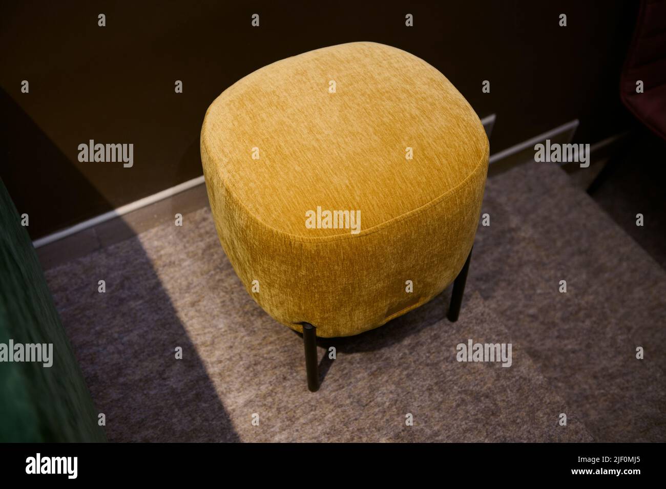 Stylish velour yellow footstool, ottoman in the furniture design studio ...