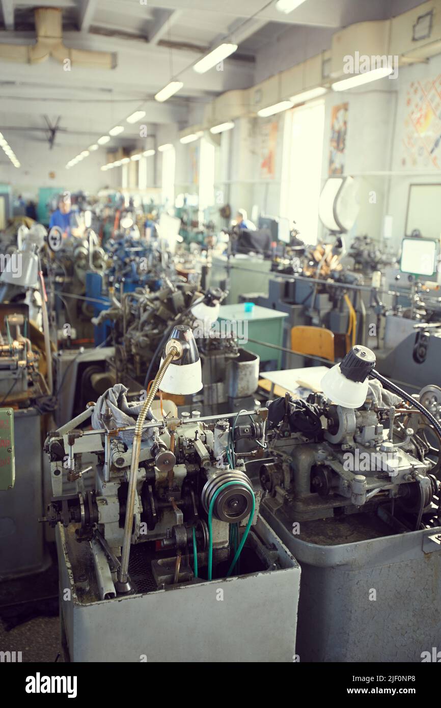 Interior of factory shop with manual lathes connected to tubes and ...