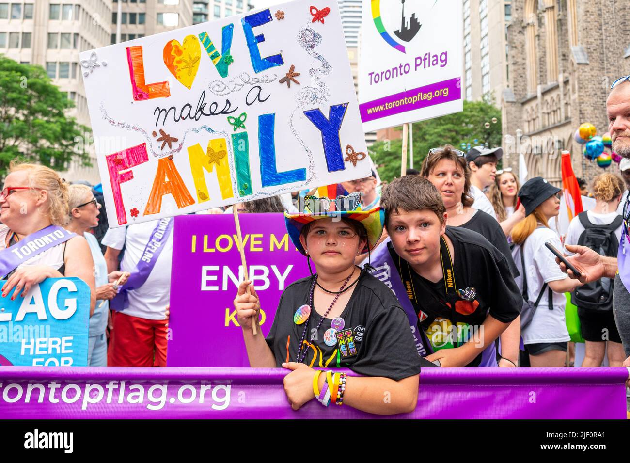 Bloc of Toronto PFlag marching in Pride Parade. A child has a sign ...