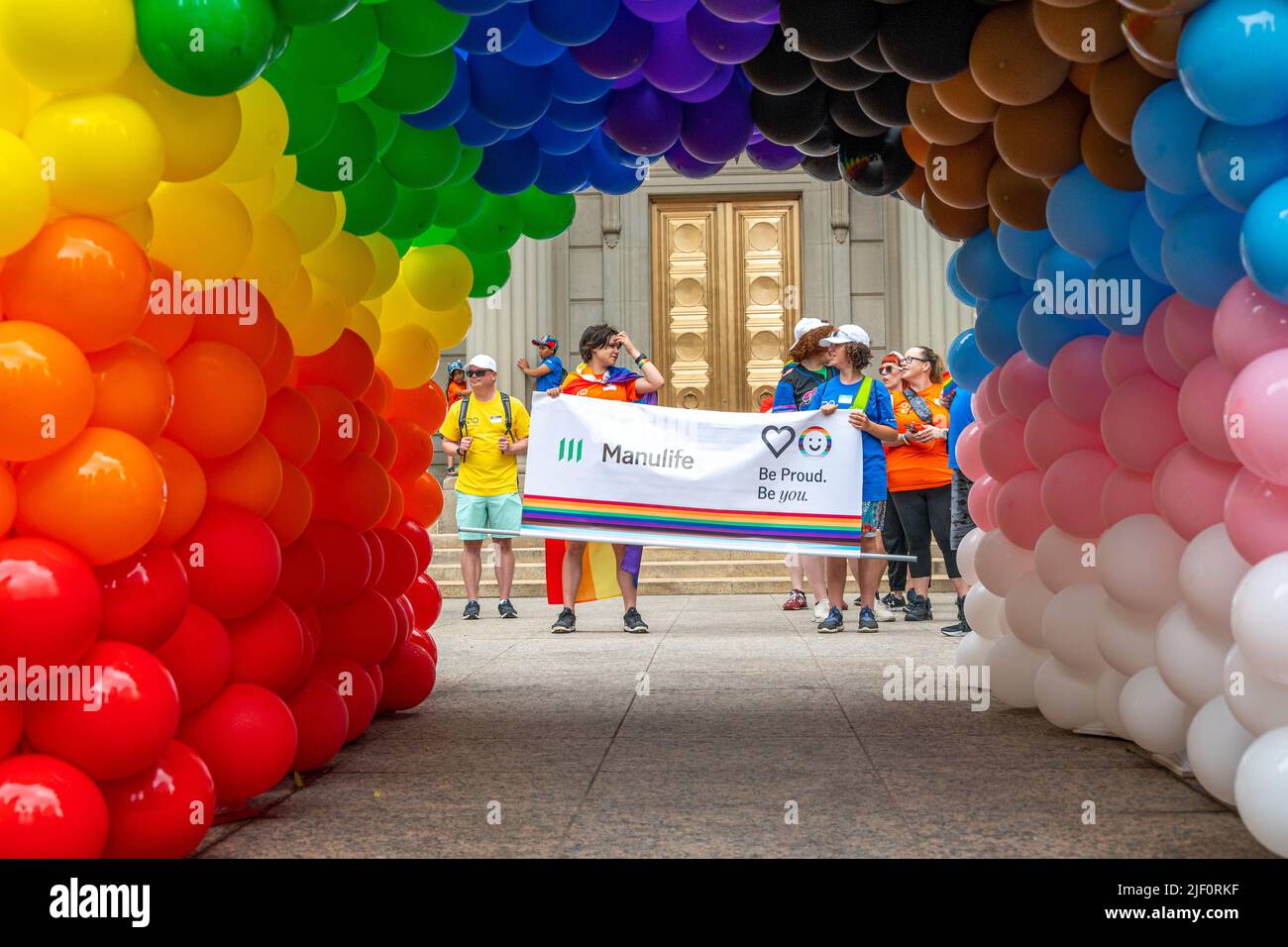 An arch made with balloons in rainbow colors decorates the entrance of ...