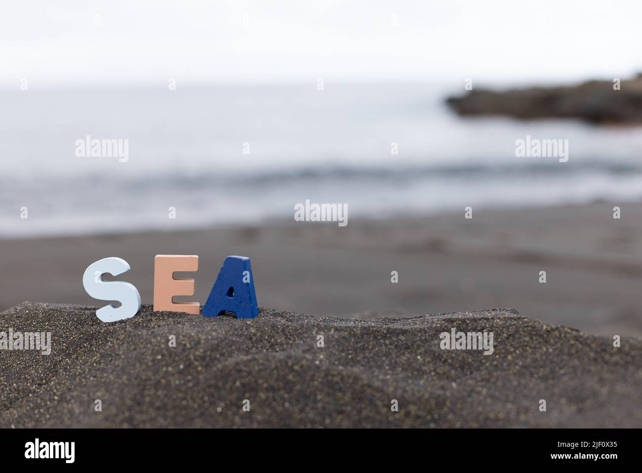 Word sea made of colourful wooden letters stand on the morning beach ...