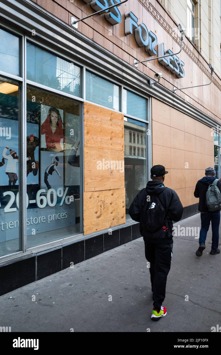 Seattle, USA. 28th Jun, 2022. People passing a boarded up smashed ...