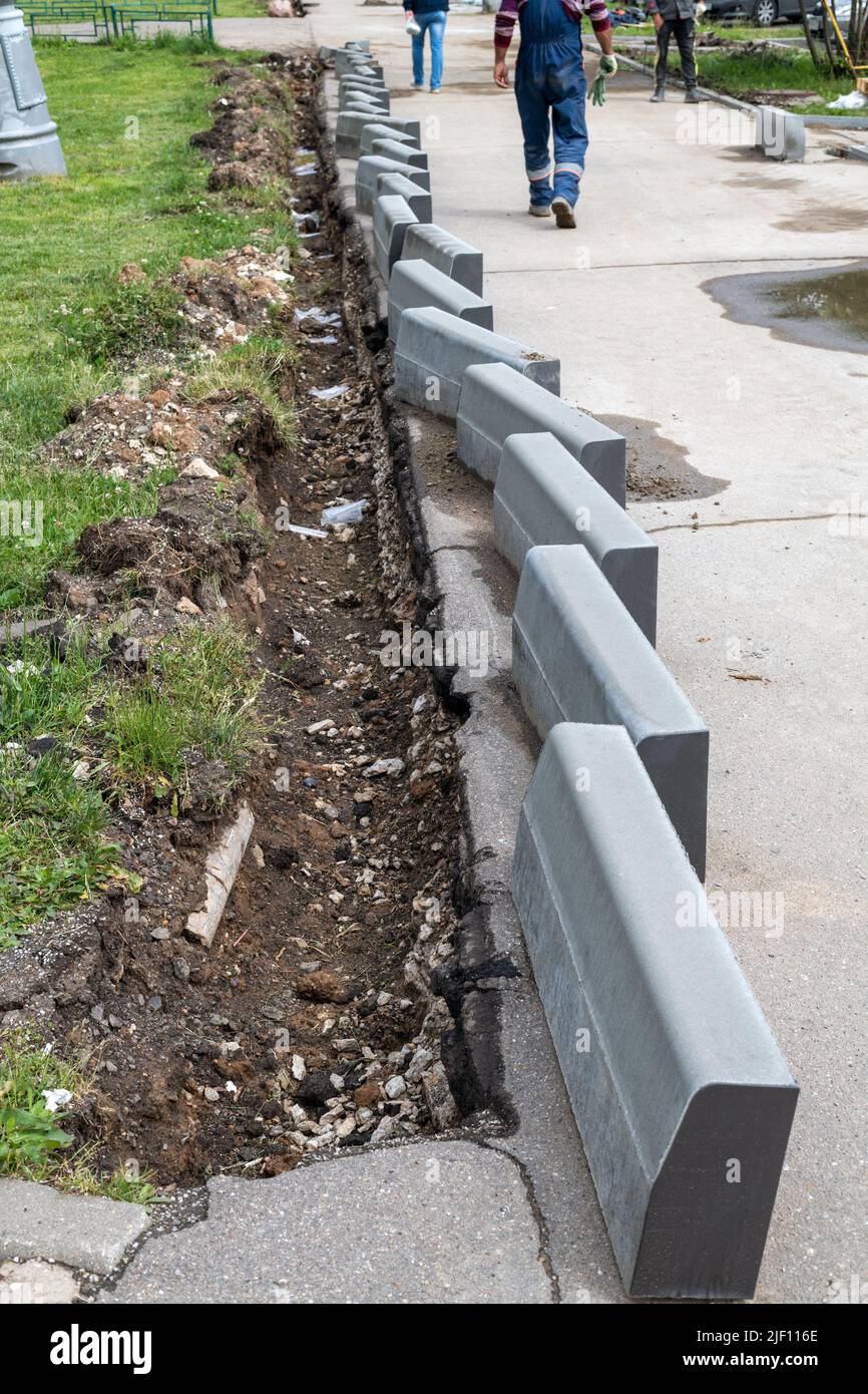 New curbs stand at the edge of the sidewalk. Preparing to repair the ...