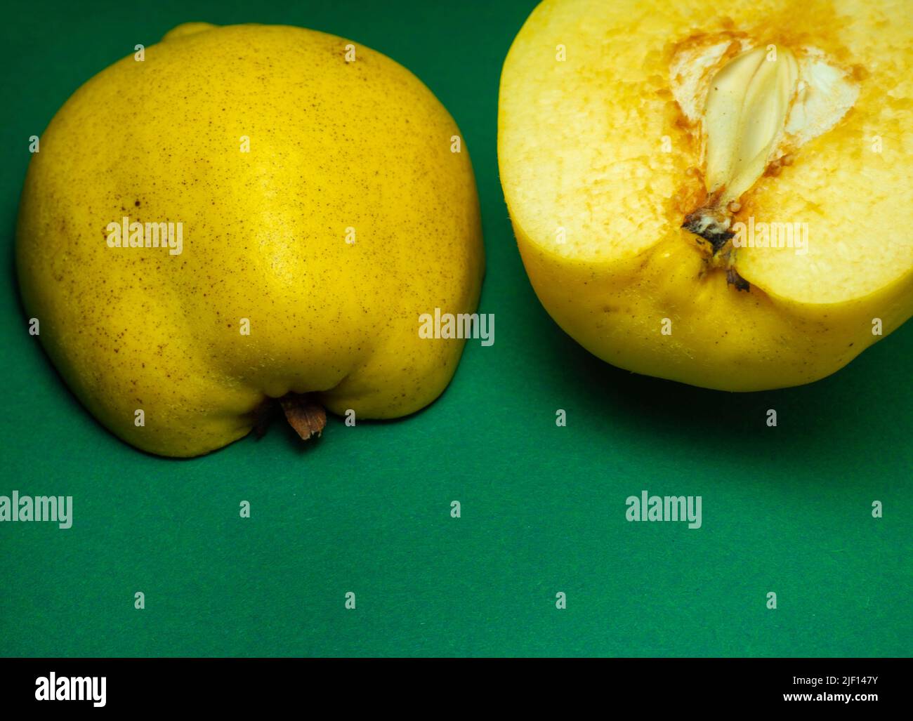 Sliced quince. Juicy fruit on a green background. Ripe useful product ...