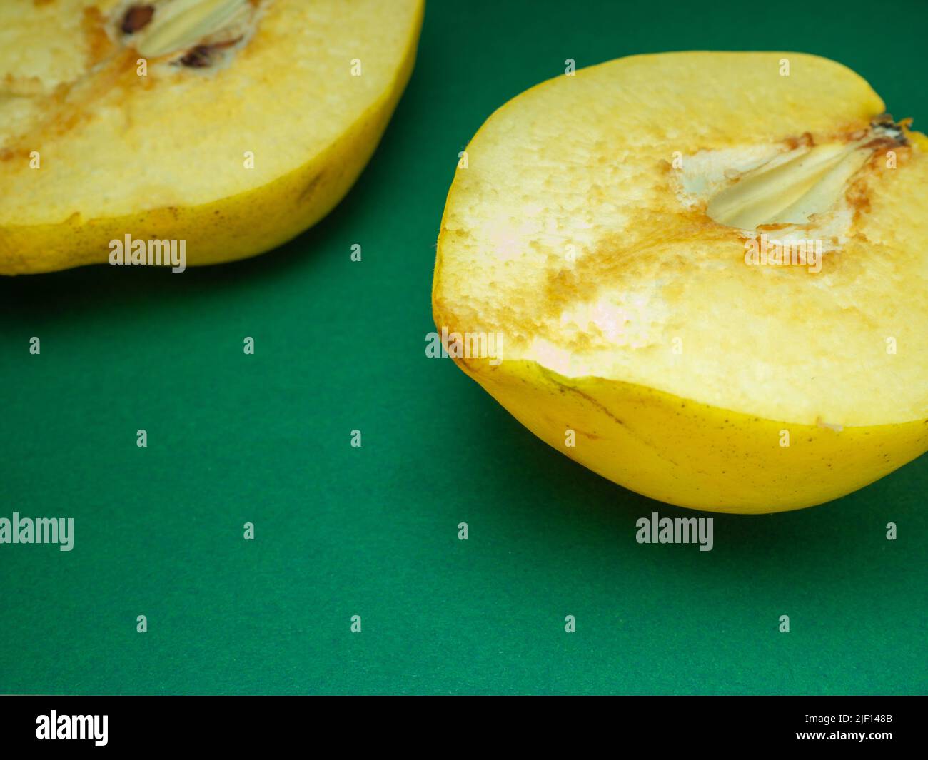 Sliced quince. Juicy fruit on a green background. Ripe useful product ...