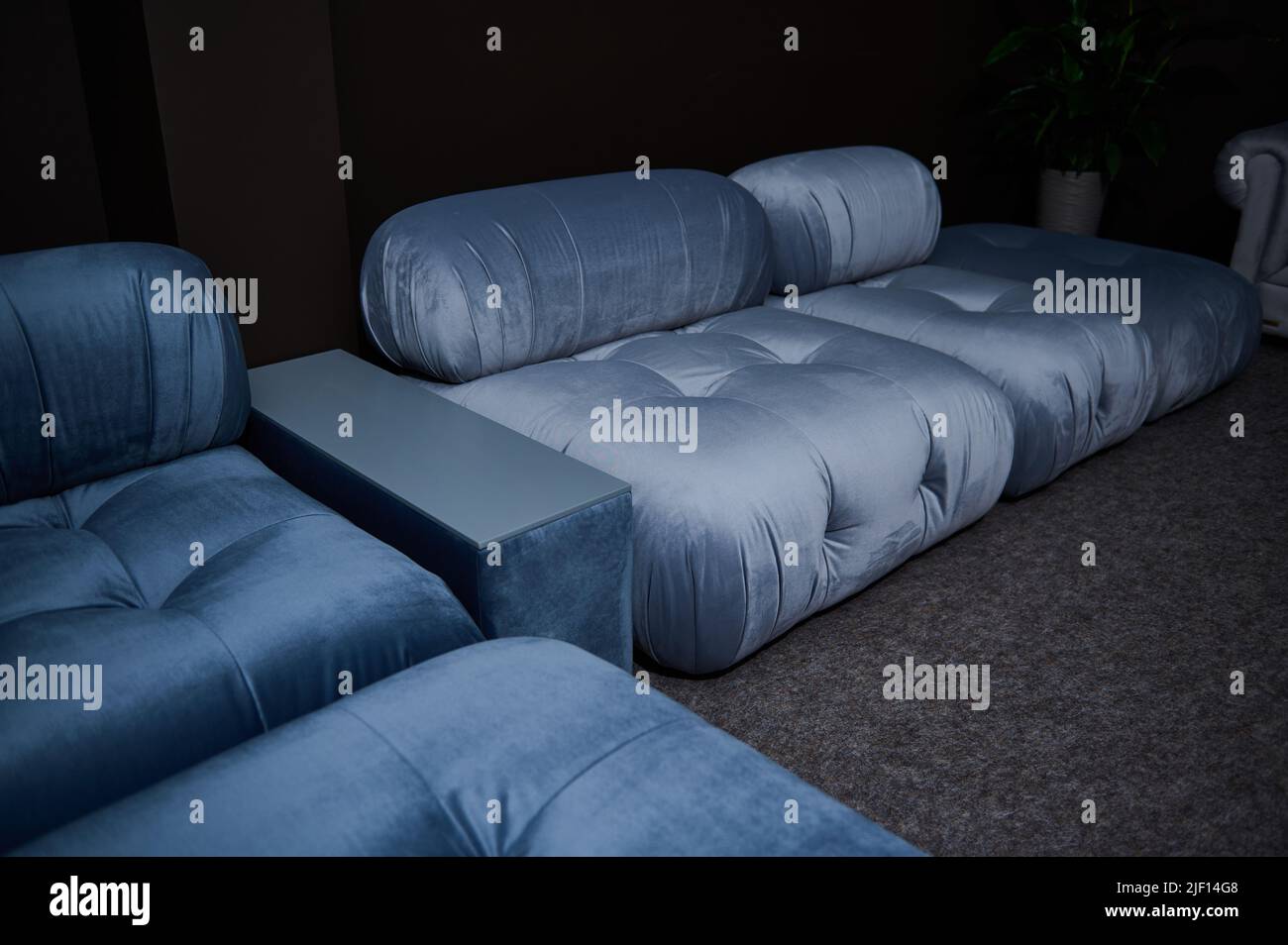 Partial view of a stylish blue satin couch displayed for sale in a ...
