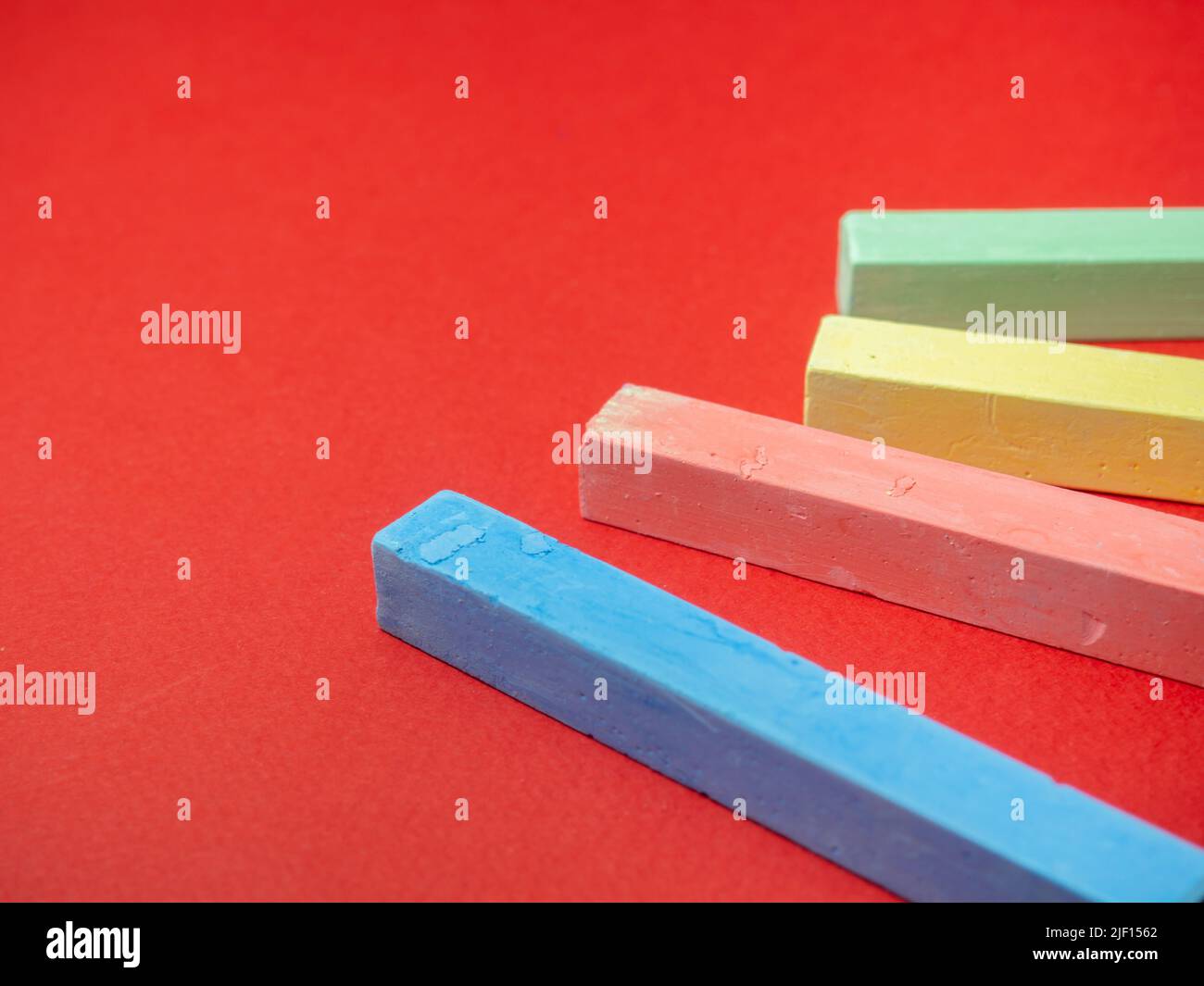 colorful crayons on a red background. Drawing accessories. Artist Tools ...