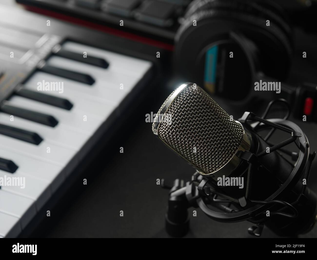 Close-up. MIDI keyboard, microphone, headphones. Modern equipment for a ...