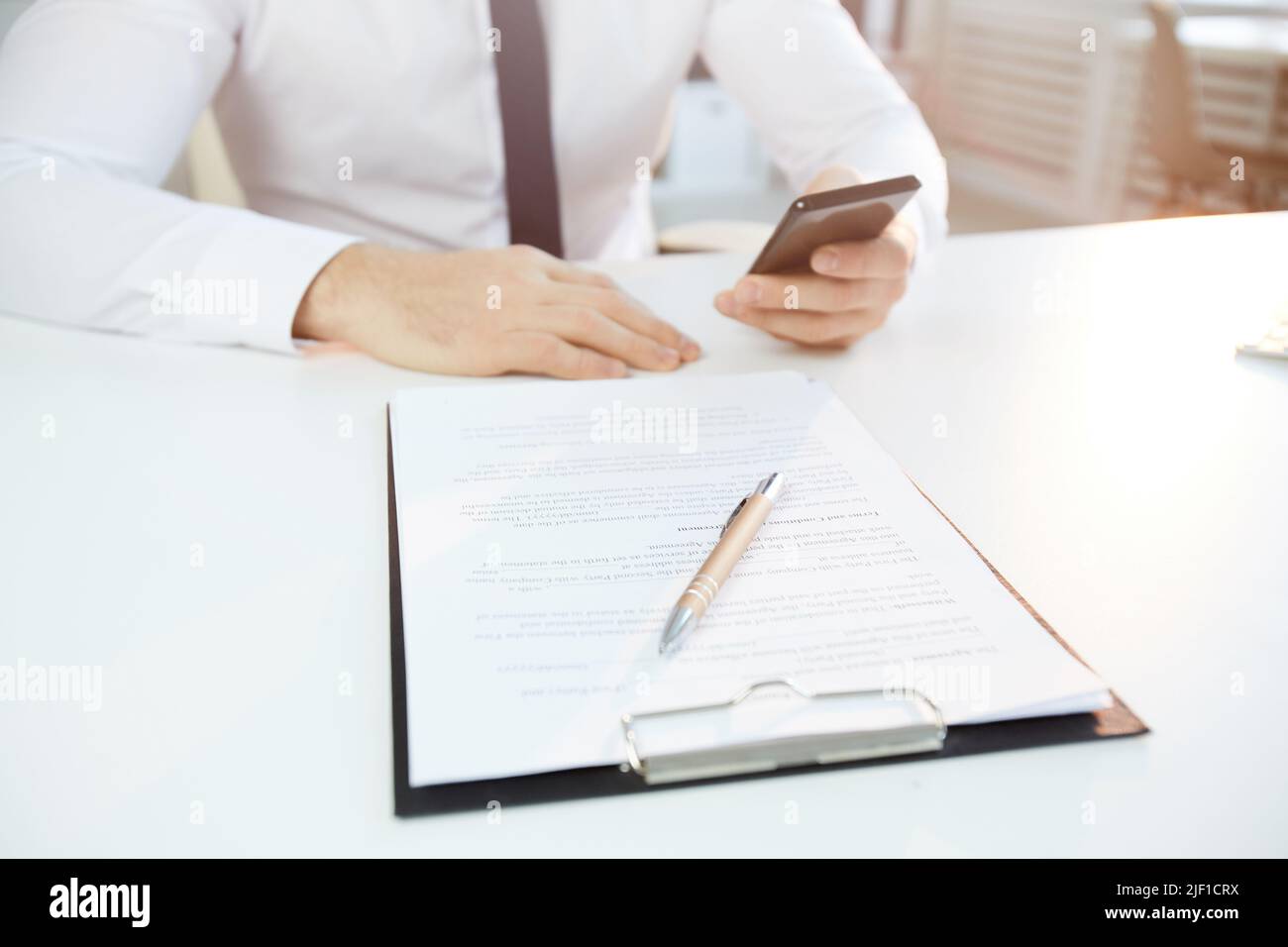 Manager in white shirt sitting at desk with computer and preparing ...