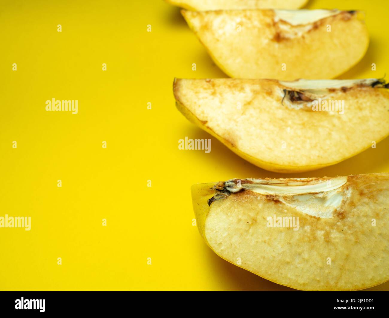 chopped quince. Juicy fruits on a yellow background. Ripe useful ...