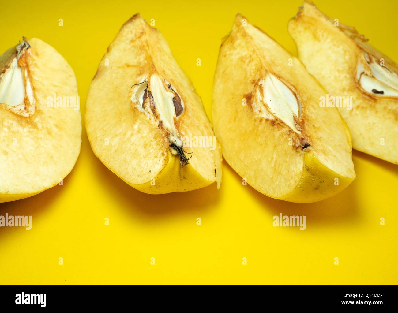 chopped quince. Juicy fruits on a yellow background. Ripe useful ...