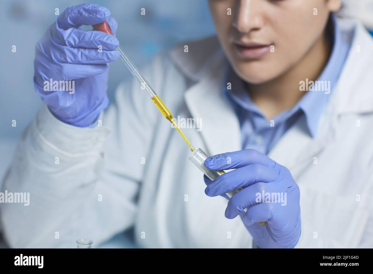Close-up of concentrated female scientist in sterile gloves and lab ...